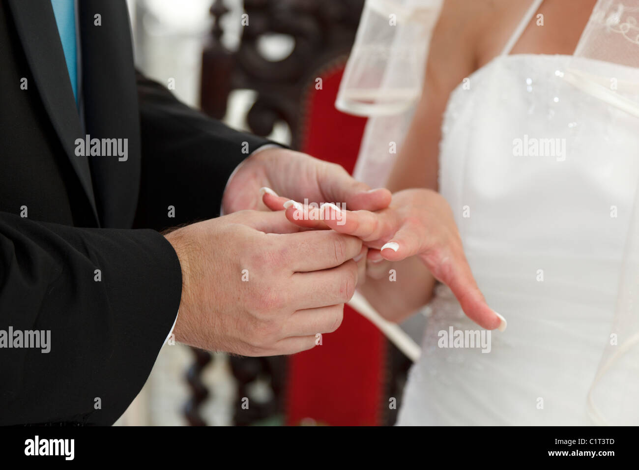 bride groom putting wedding ring onto brides finger Stock Photo - Alamy
