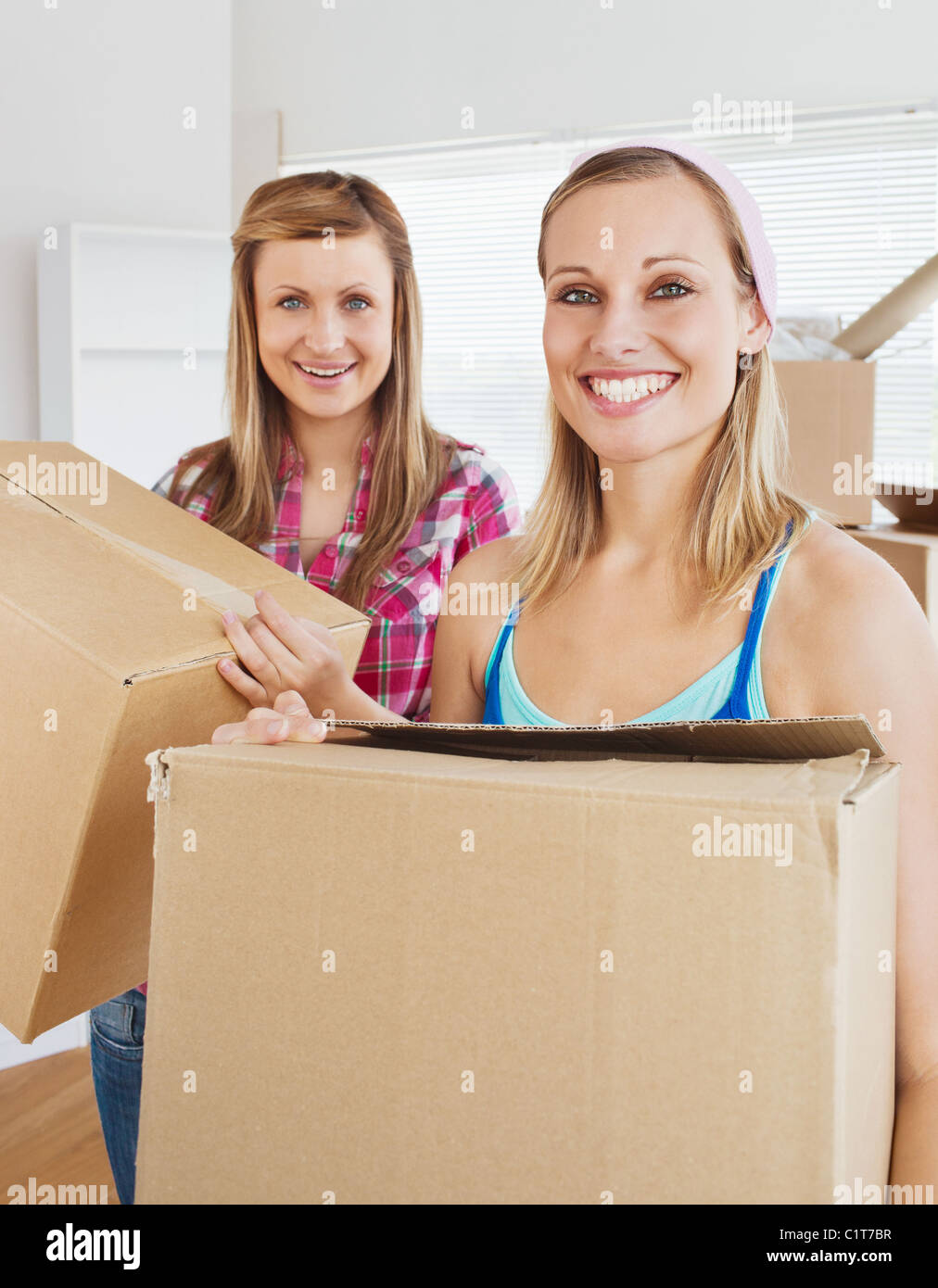 Charming friends holding boxes Stock Photo - Alamy