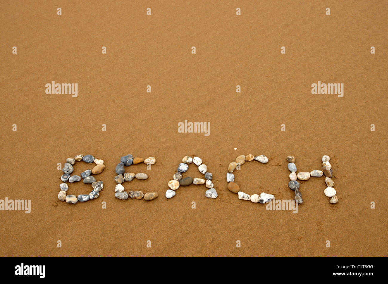 Beach in Stone writing beach sea sand seaside Stock Photo - Alamy