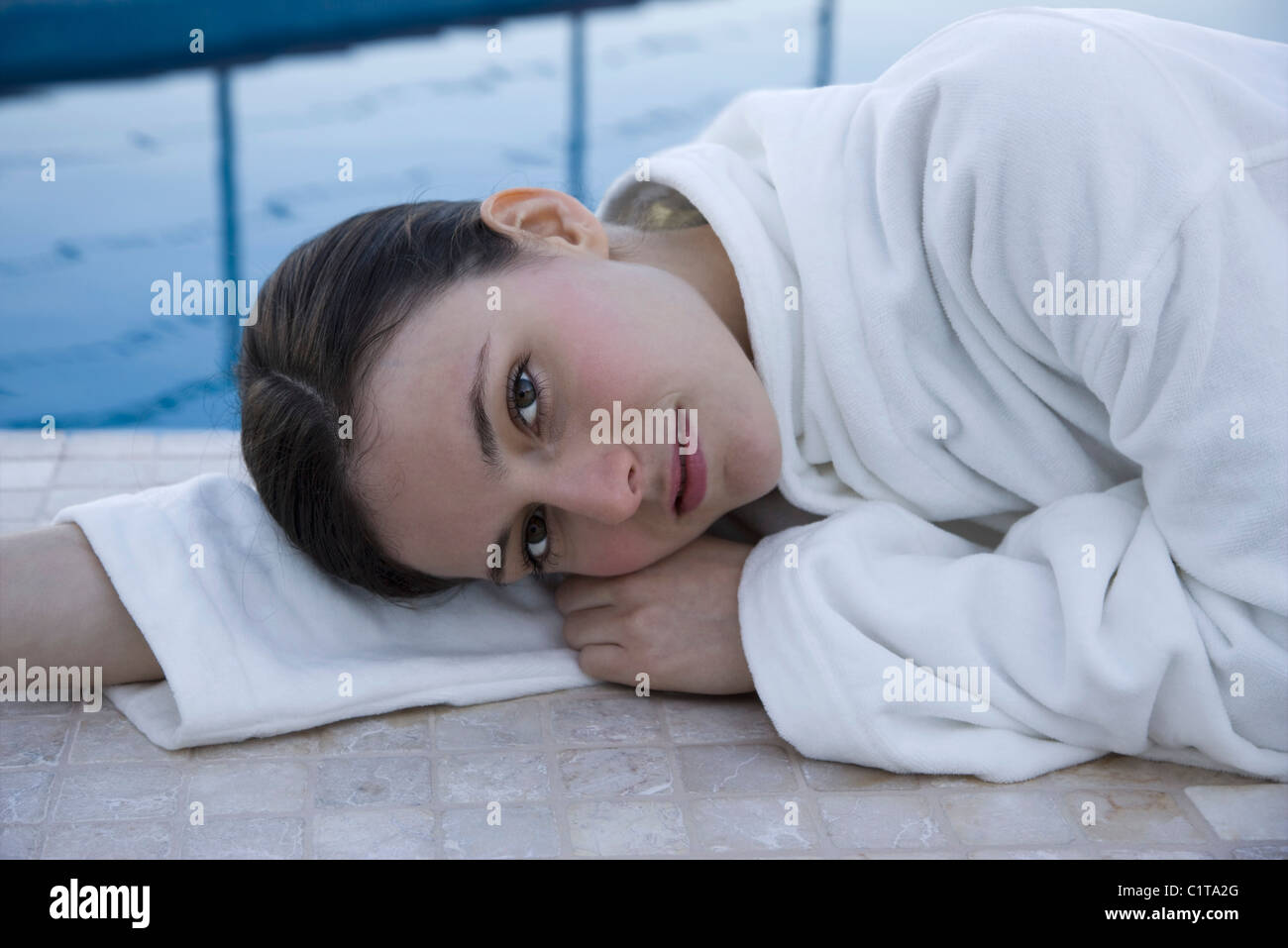Woman lying on side next to pool, portrait Stock Photo - Alamy