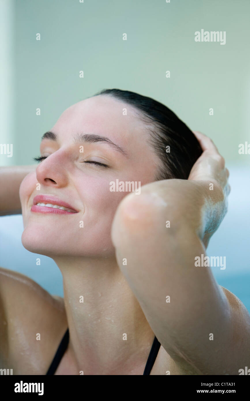 Woman smoothing back wet hair, eyes closed Stock Photo - Alamy