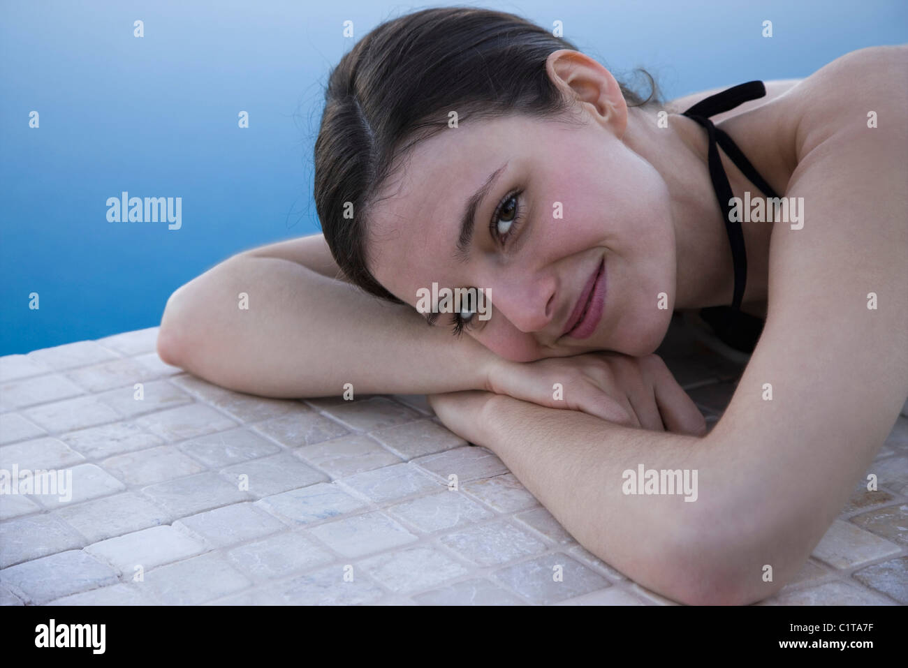 Woman lying beside pool, portrait Stock Photo - Alamy