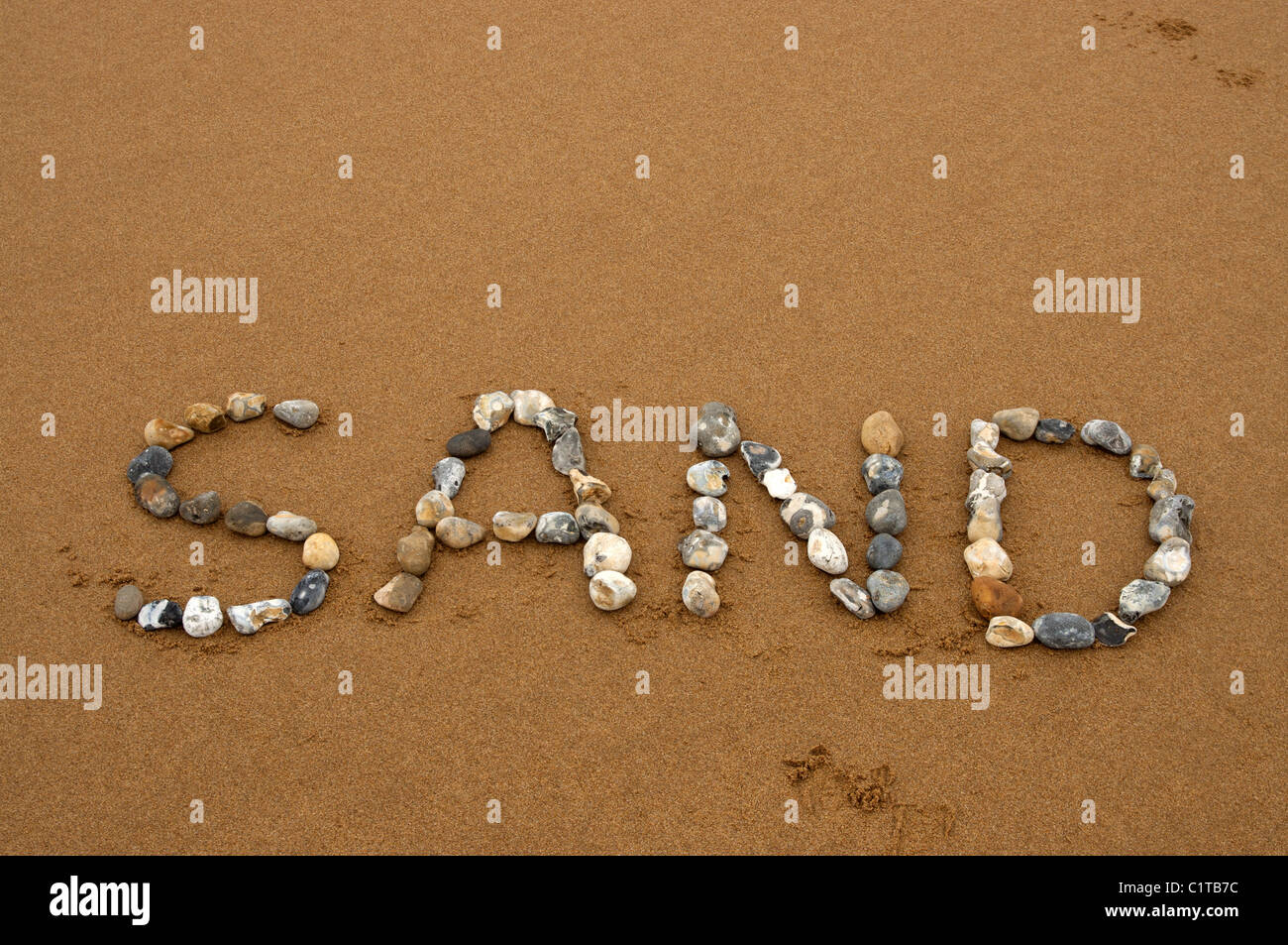 Sand in Stone writing beach sea sand seaside Stock Photo - Alamy
