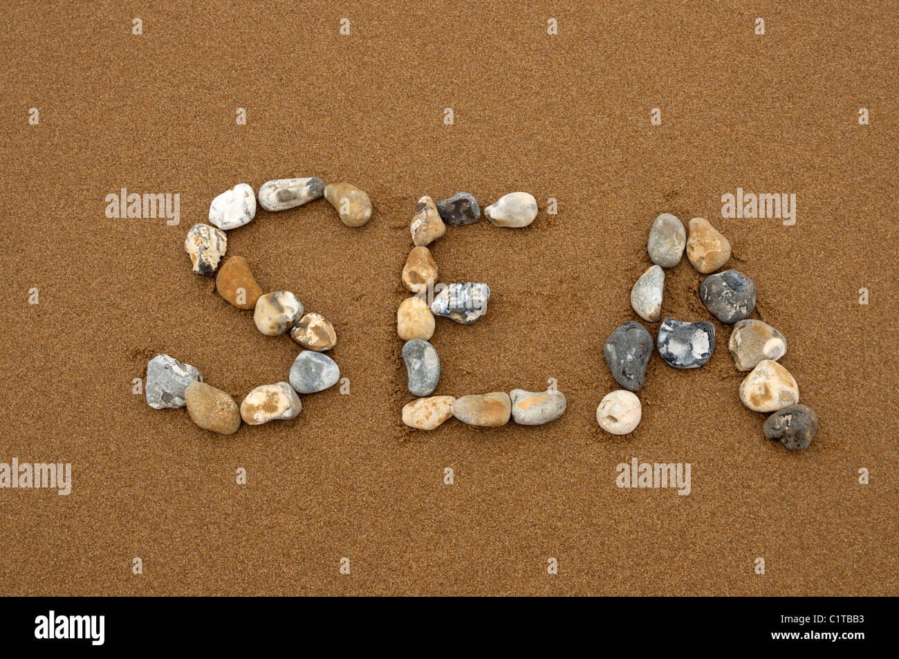 Sea in Stone writing beach sea sand seaside Stock Photo - Alamy
