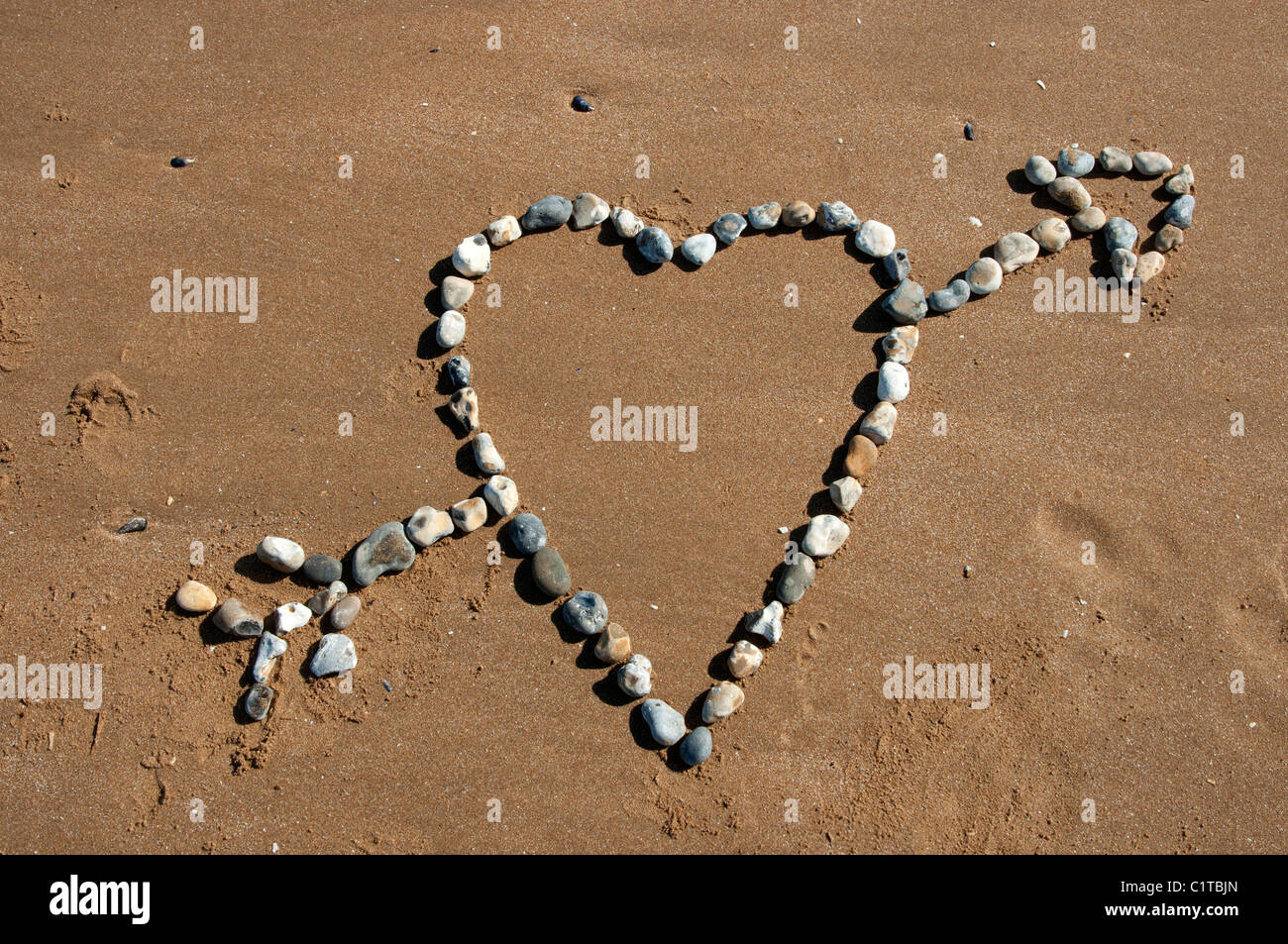 Heart of stone with arrow writing beach sea sand seaside Stock Photo ...