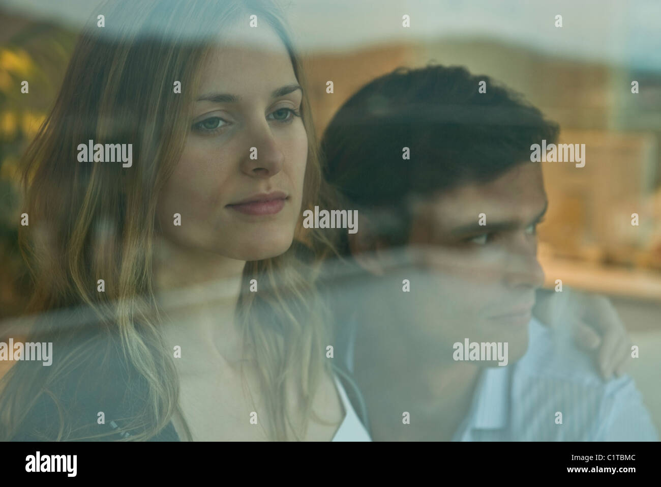 Couple looking through window, portrait Stock Photo - Alamy