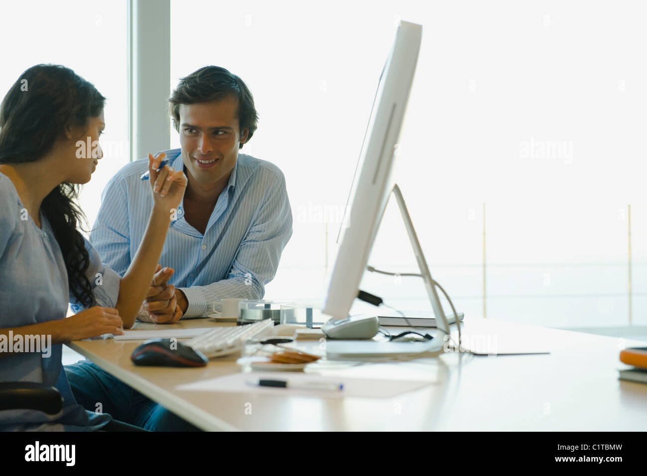 Couple sitting together at computer desk Stock Photo - Alamy