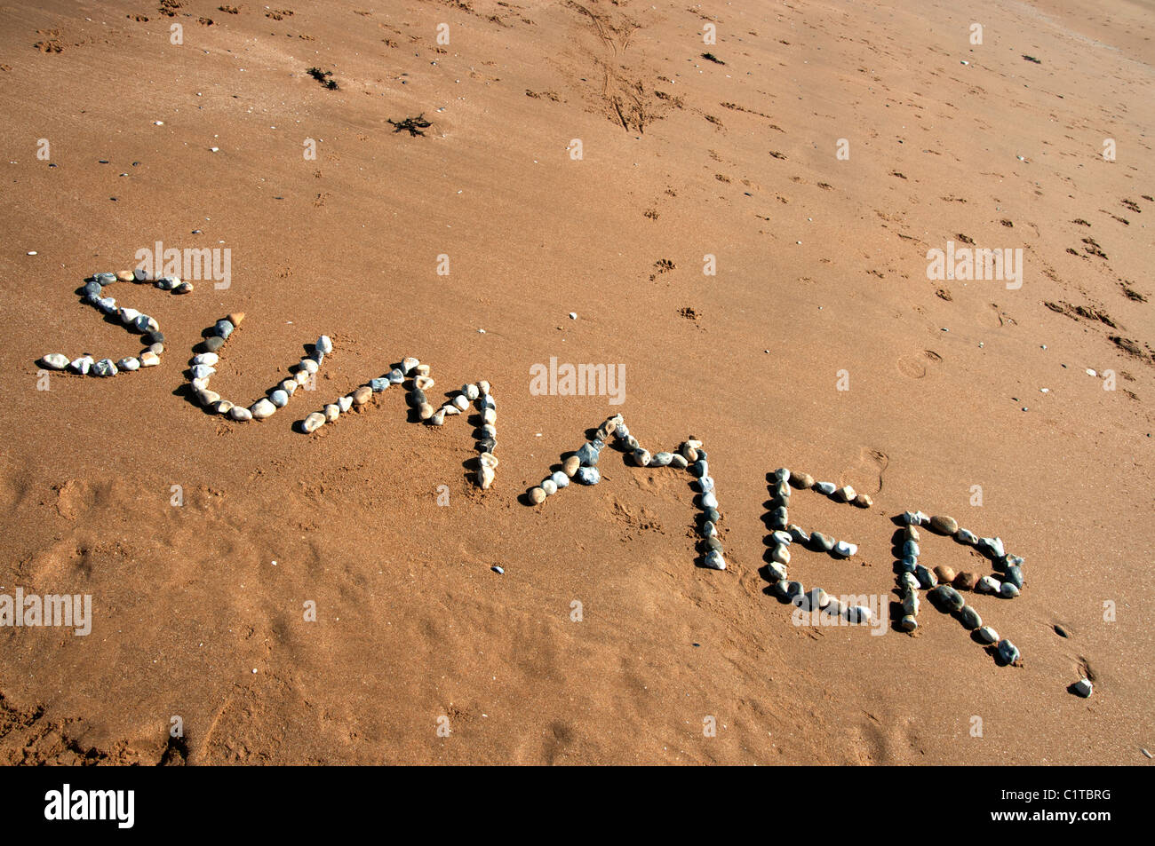 Summer in Stone writing beach sea sand seaside Stock Photo - Alamy