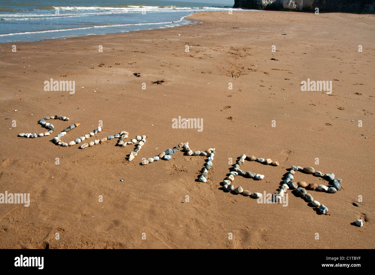 Summer in Stone writing beach sea sand seaside Stock Photo - Alamy