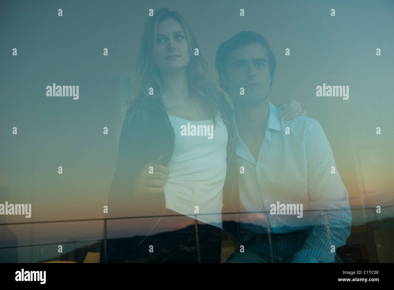 Couple looking out window together Stock Photo - Alamy