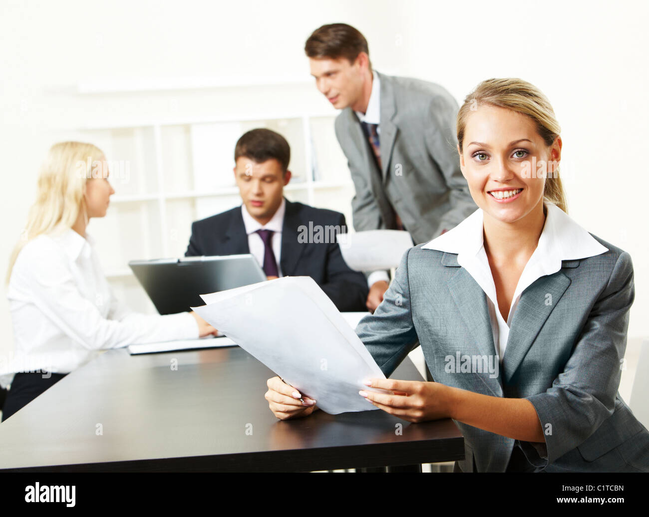 Photo of attractive secretary holding paper and looking at camera ...