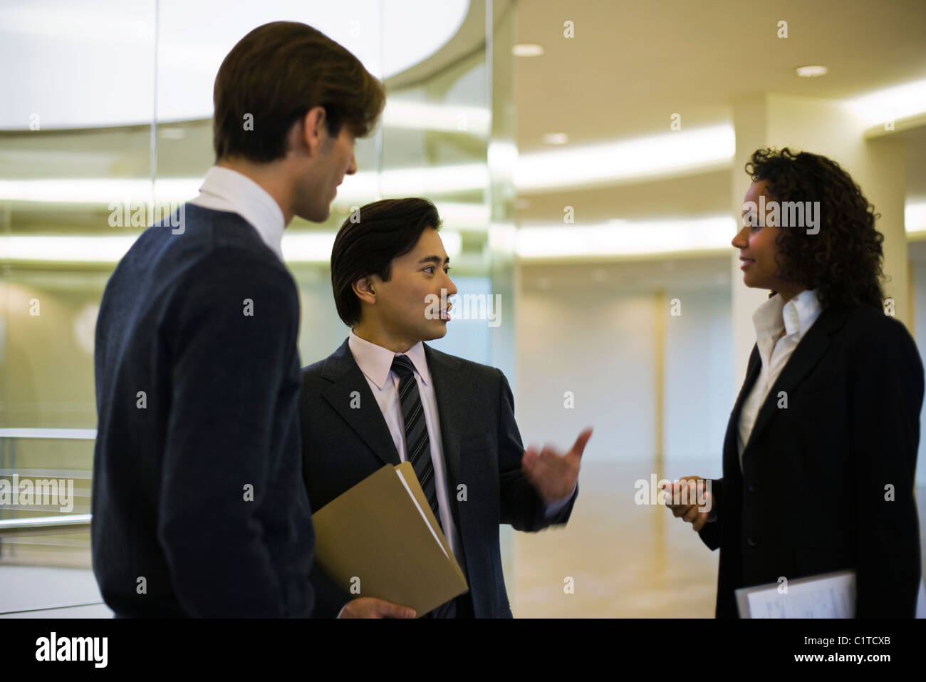 Executives talking in corridor Stock Photo - Alamy