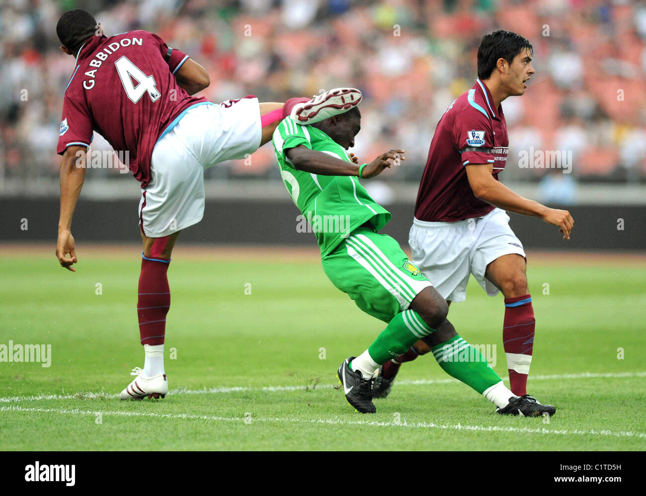 West Ham United`s Daniel Gabbidon challenges Beijing Guoan`s Bryan ...
