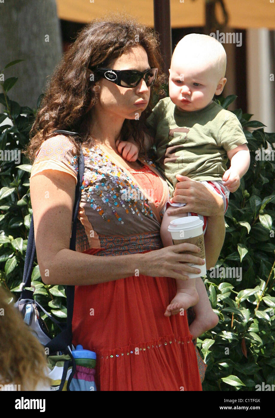 Actress Minnie Driver holding a coffee, carrying her son Henry in Cross ...