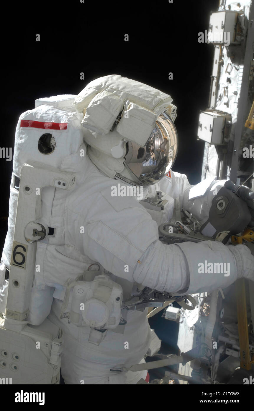 An astronaut performs a task on the exterior of the International Space ...