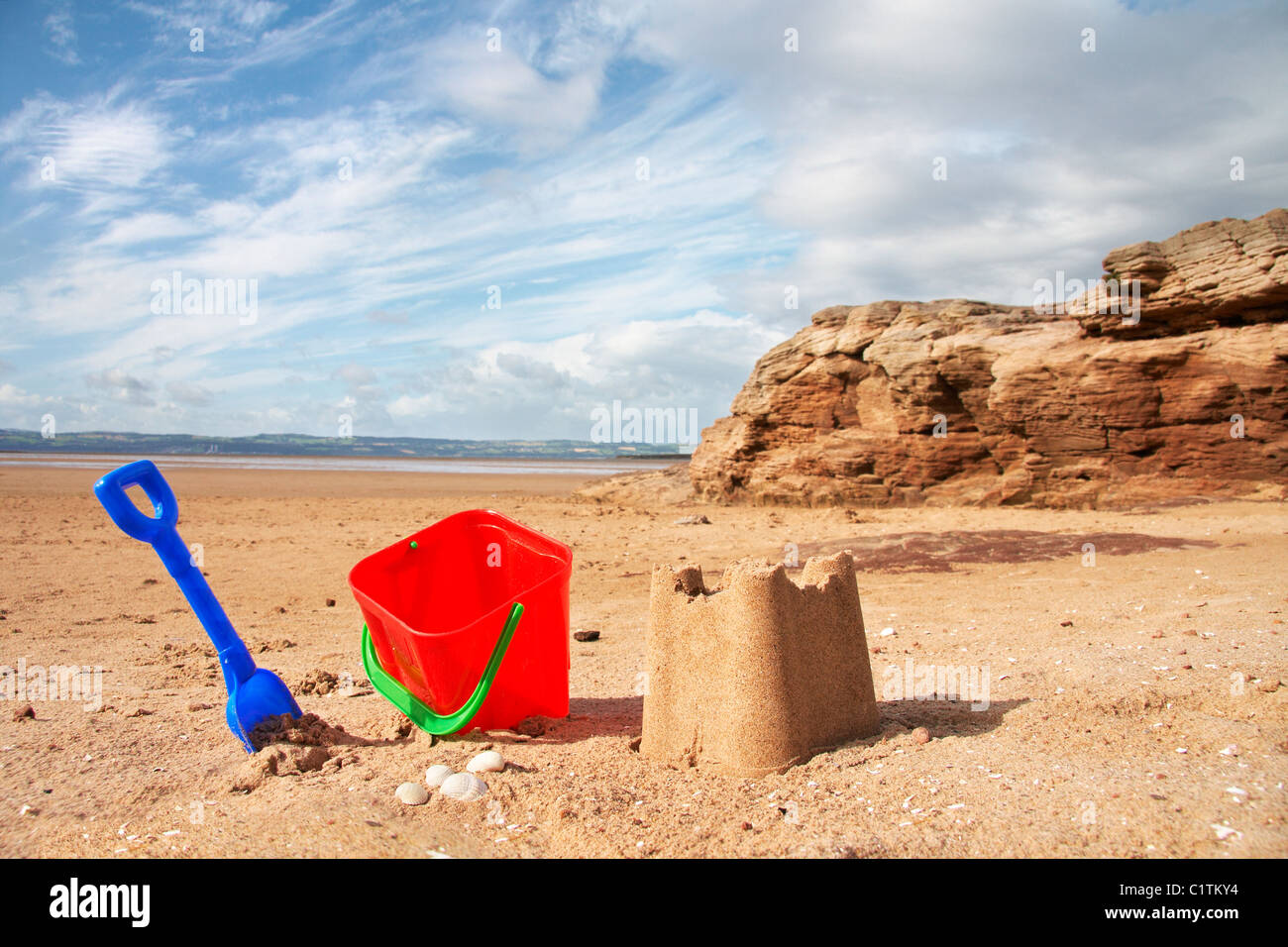 Bucket, spade, sandcastle and sea shells on a beach in summer Stock ...