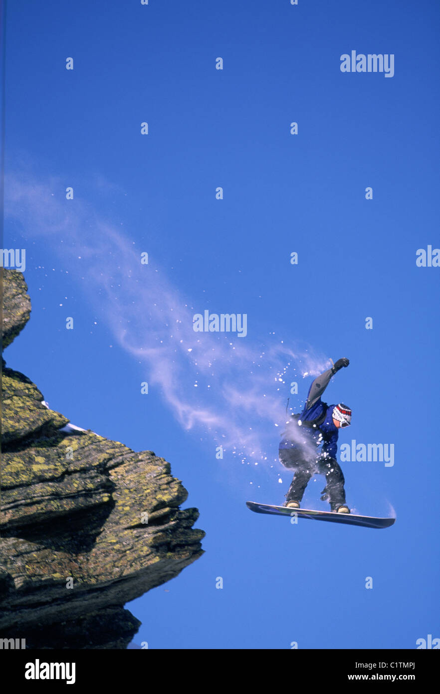 Teenager jumping off cliff on snowboard Stock Photo - Alamy
