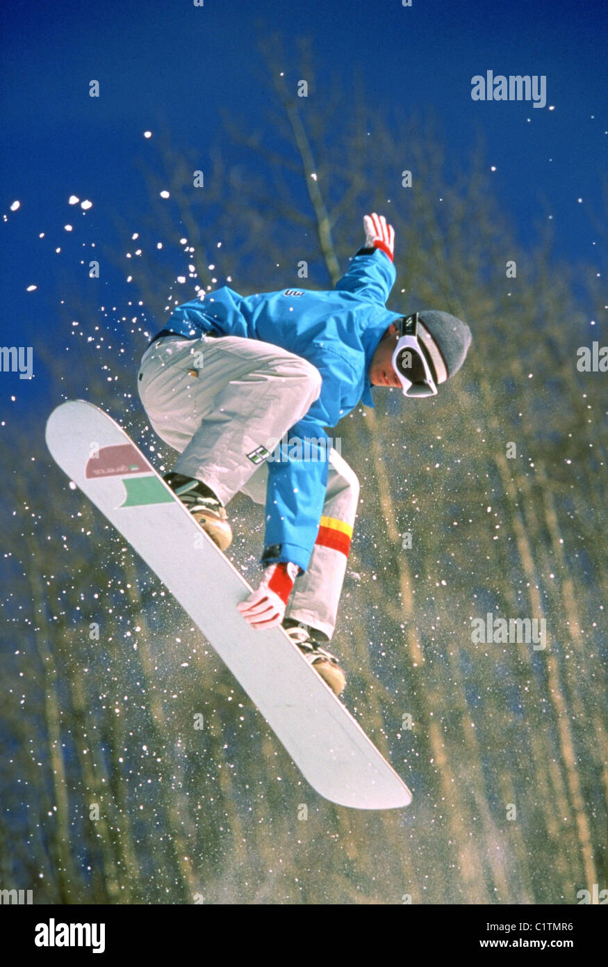 Young adult man performing stunt on snowboard Stock Photo - Alamy