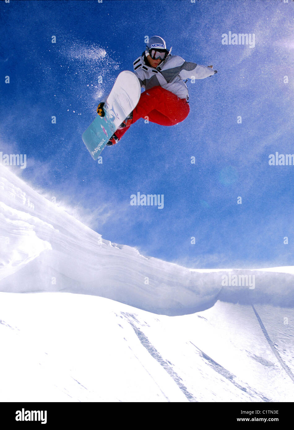 Teenage boy performing stunt on snowboard Stock Photo - Alamy