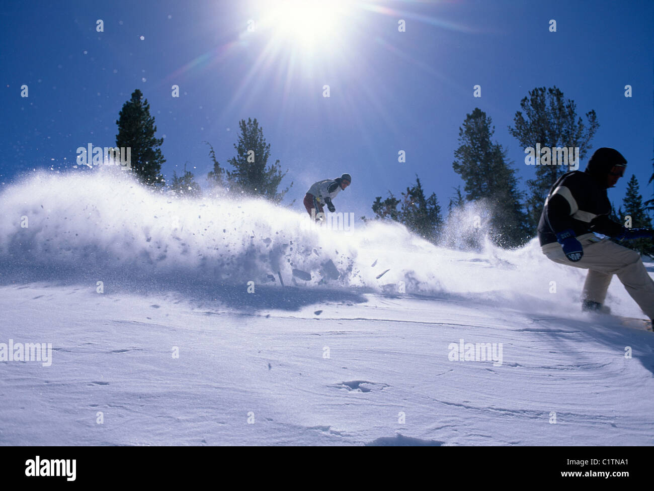 Low angle view of two people snowboarding Stock Photo - Alamy