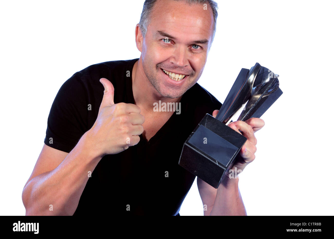 Middle aged man holding winning trophy and giving the thumbs up after ...