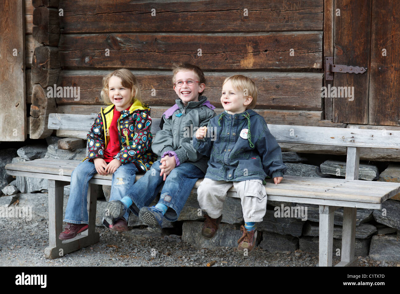 three children on wooden bench Stock Photo - Alamy