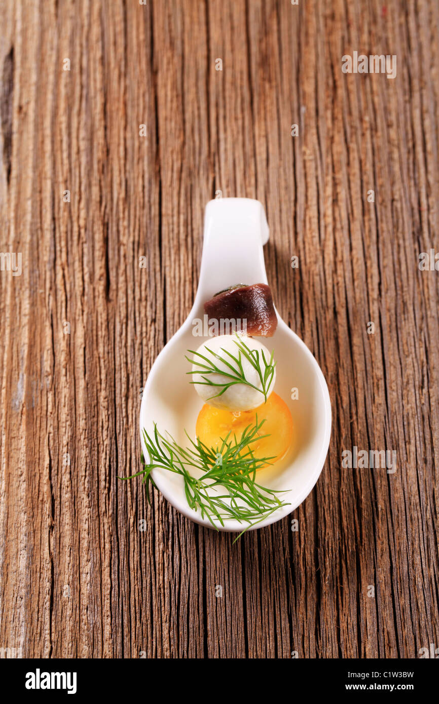 Baby mozzarella, tomato and anchovy on porcelain spoon Stock Photo - Alamy