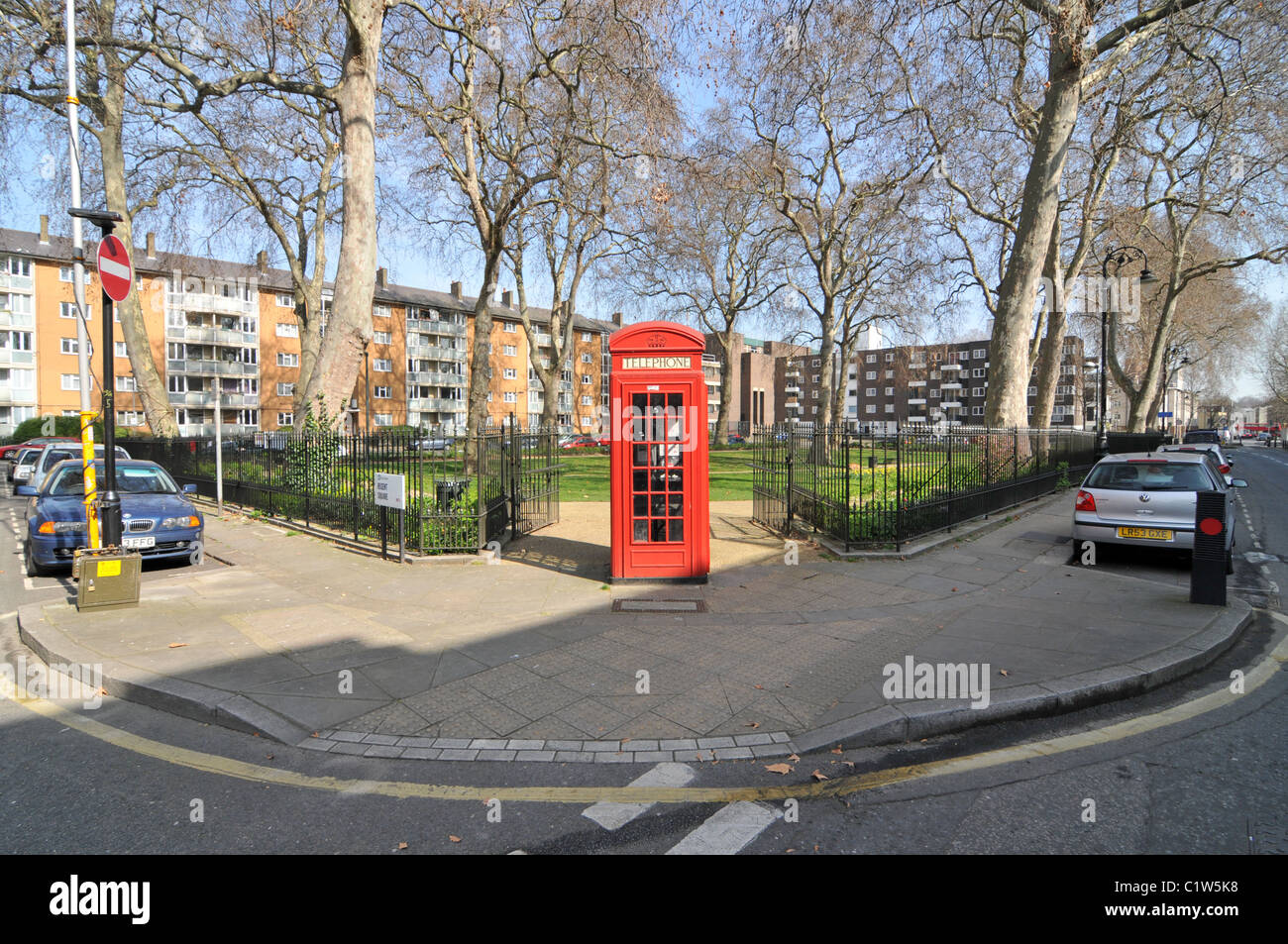 Red telephone box centre road corner cars parked still static balanced ...