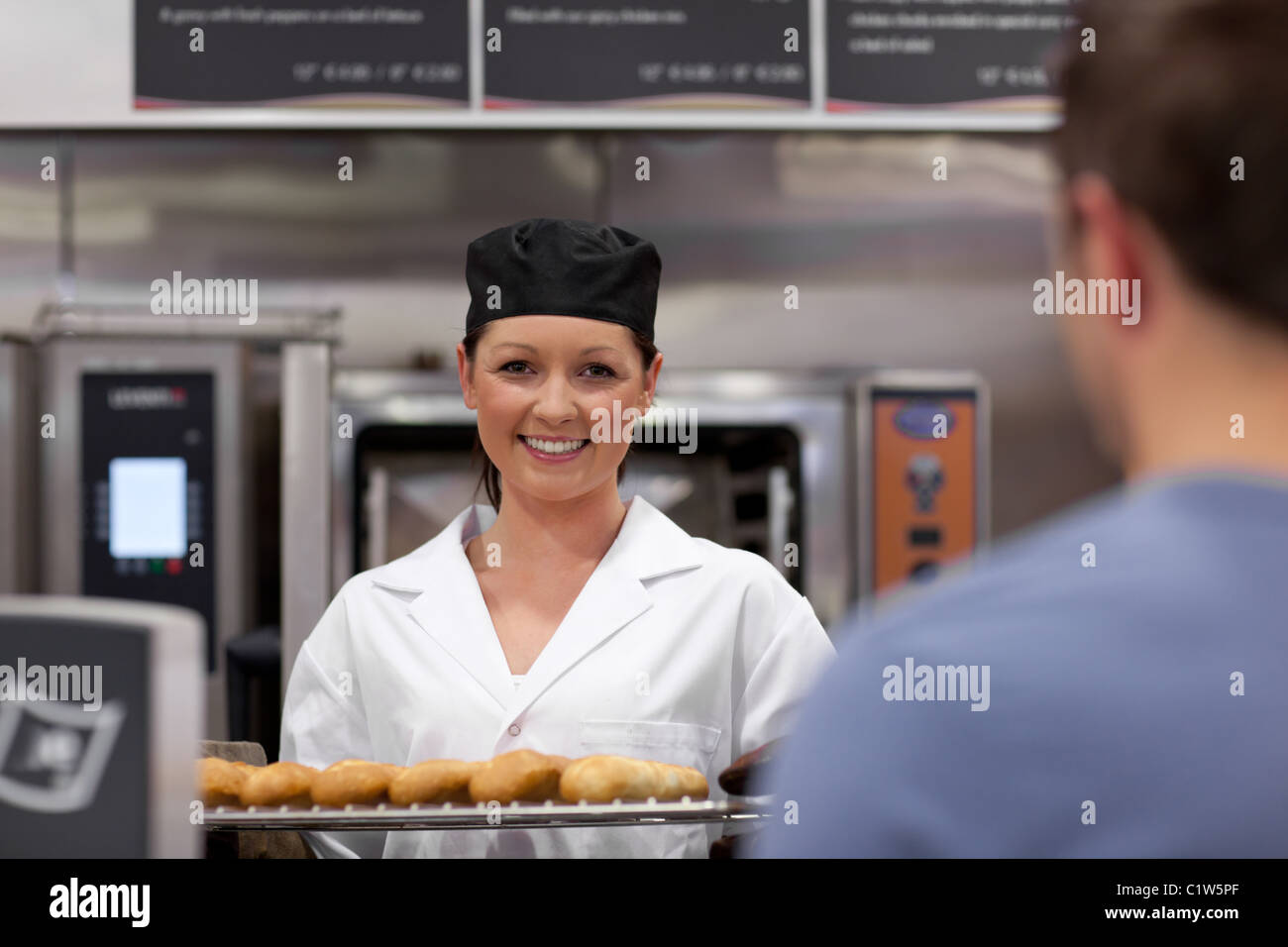 Glowing young baker with baguettes Stock Photo - Alamy