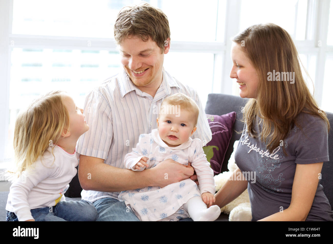 Portrait of happy family relaxing in the living room at home Stock ...
