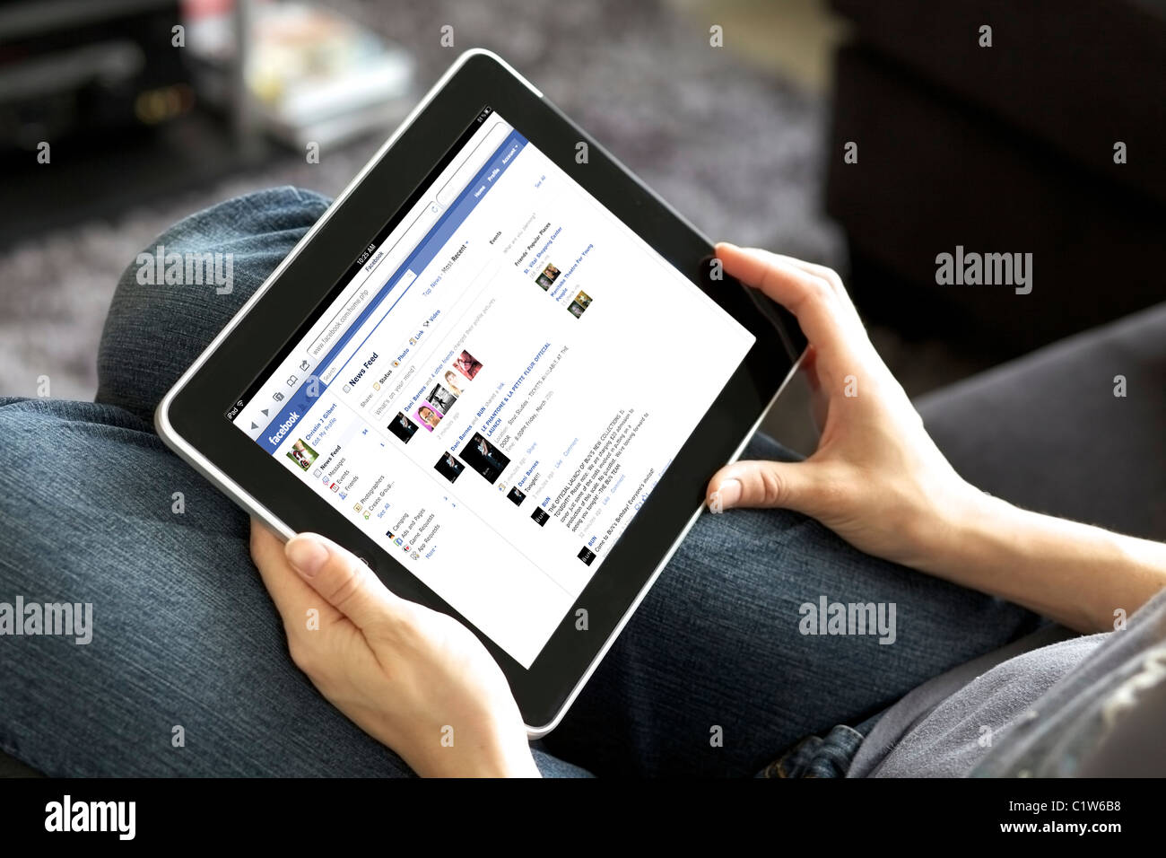 Close up view of a woman handholding an ipad reading her Facebook ...