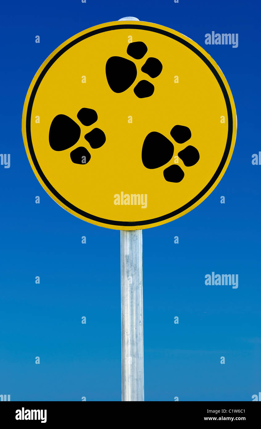 Circular Sign with animal paw prints on it on a blue sky background ...