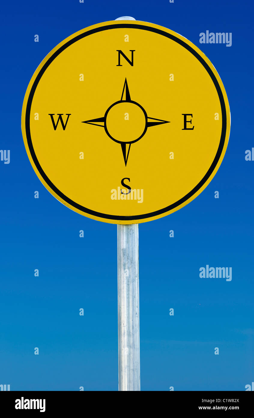 Compass symbol on a yellow sign on a blue background Stock Photo - Alamy