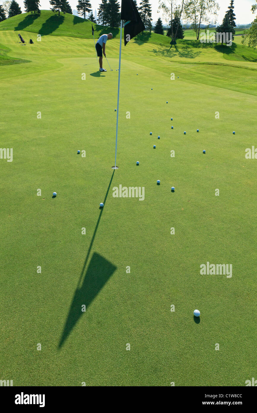 Golfer practising putting on golf range Stock Photo - Alamy