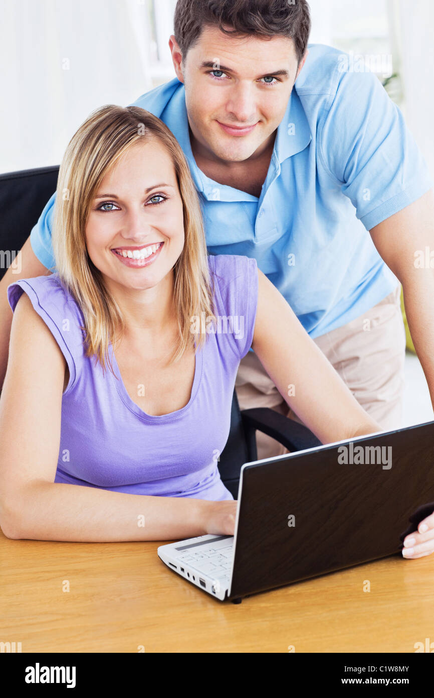 Smiling couple using computer on the desk Stock Photo - Alamy