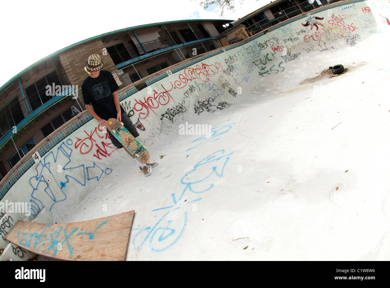 A young boy skating an old drained pool Stock Photo - Alamy