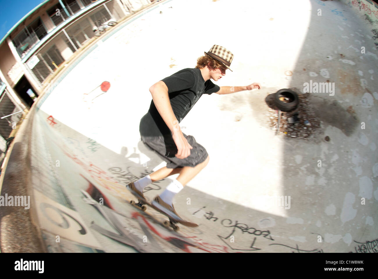 A young boy skating an old drained pool Stock Photo - Alamy
