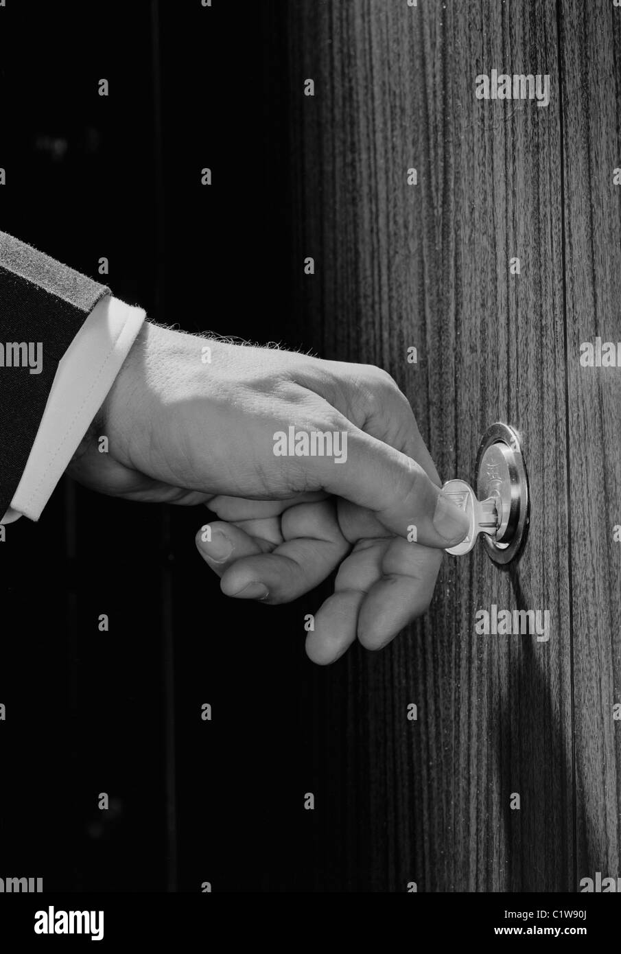 Mans hand turning key in door Stock Photo - Alamy