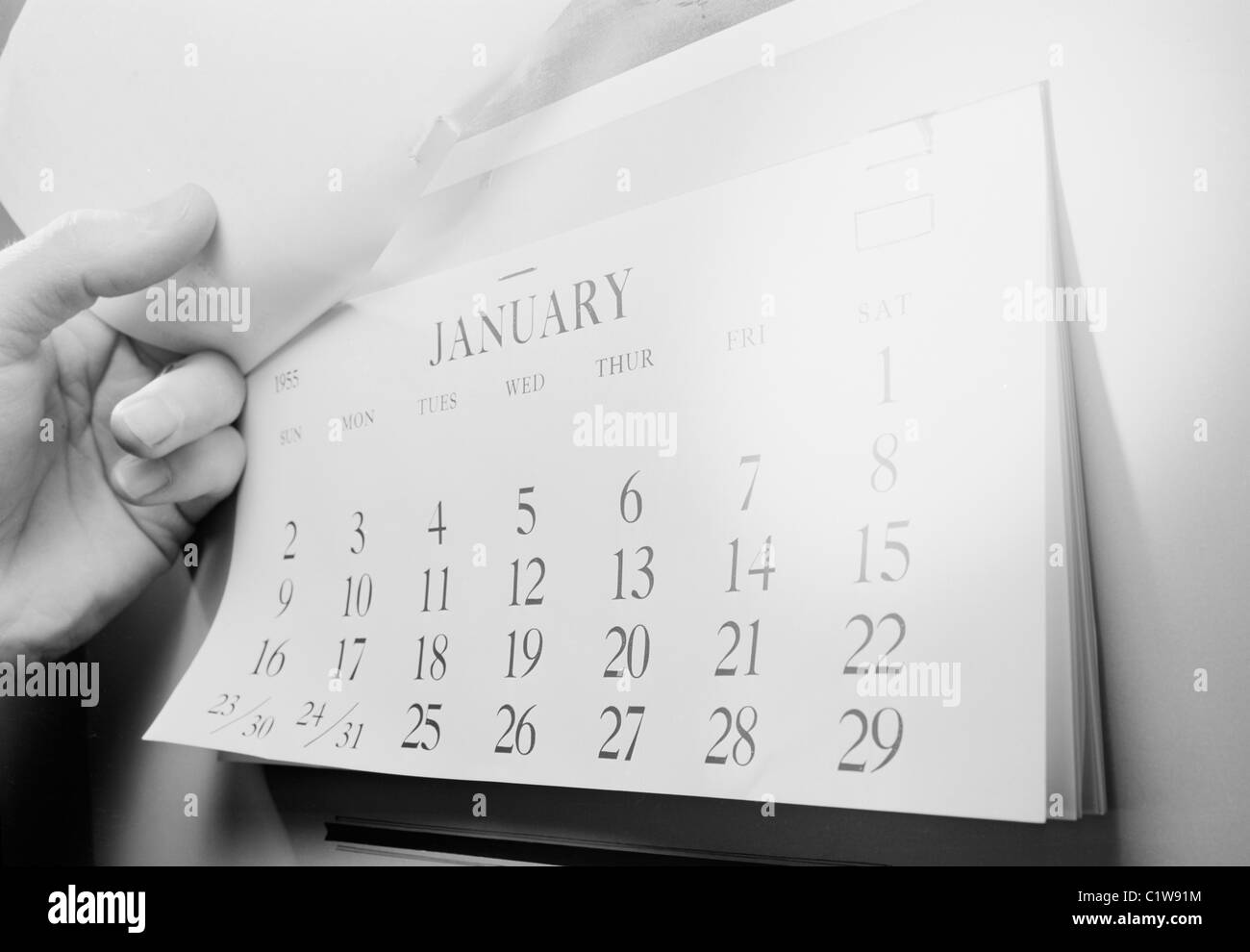 Hand opening calendar showing January Stock Photo - Alamy