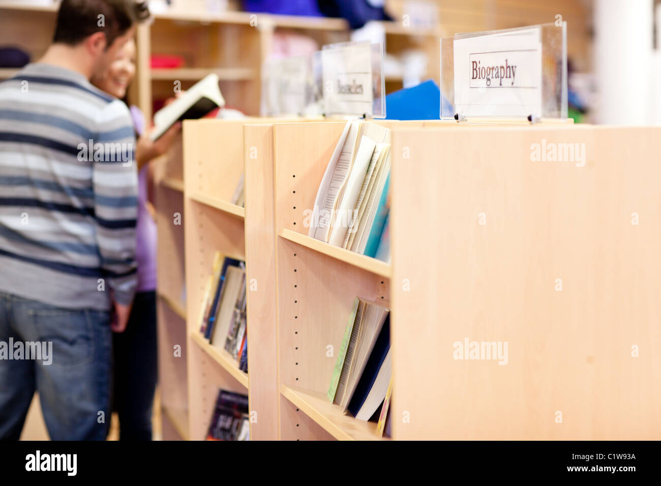 Close-up of a bookshelves in a library with students reading book Stock ...