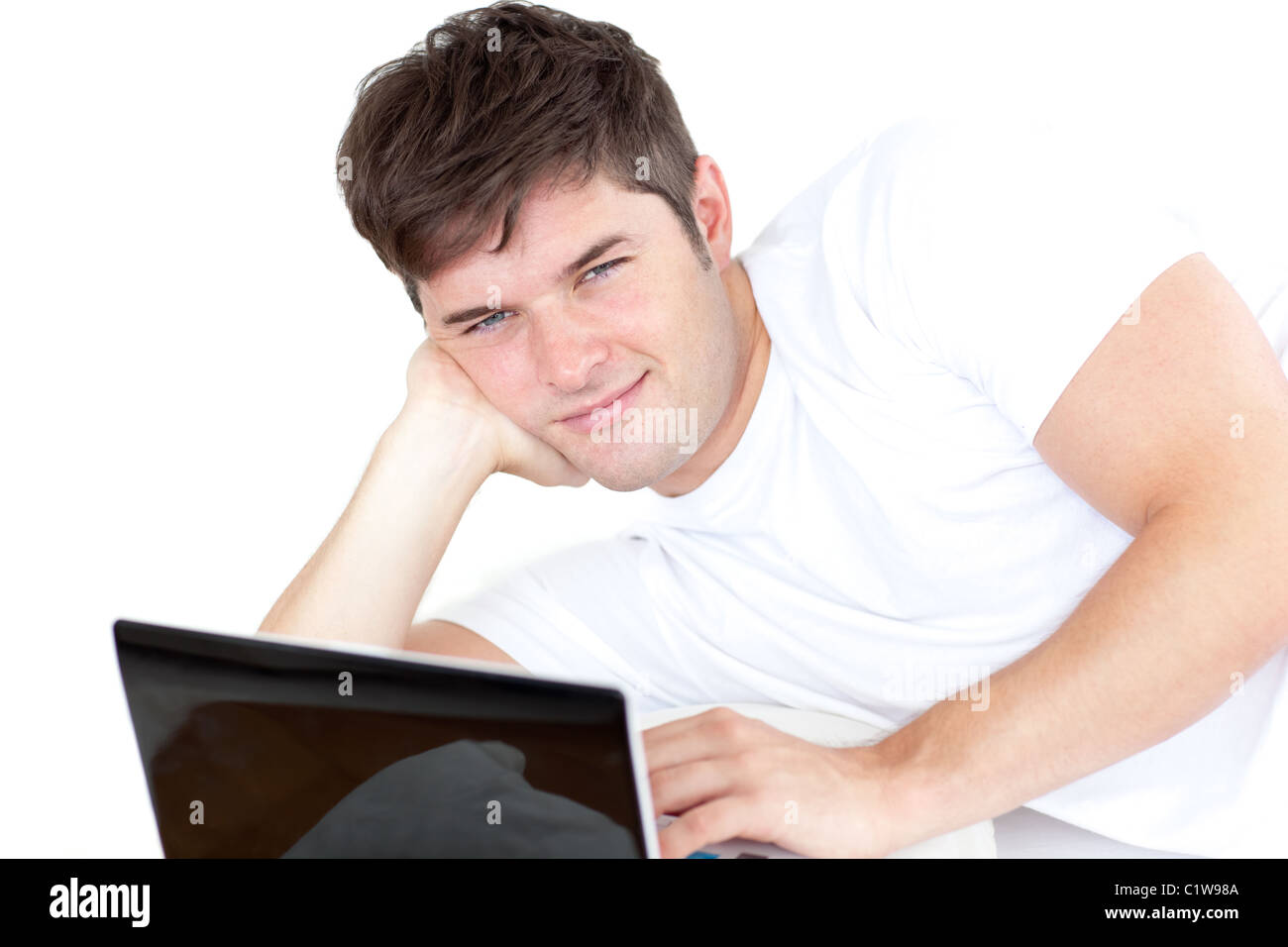 Attractive young man using his computer lying on the floor Stock Photo ...