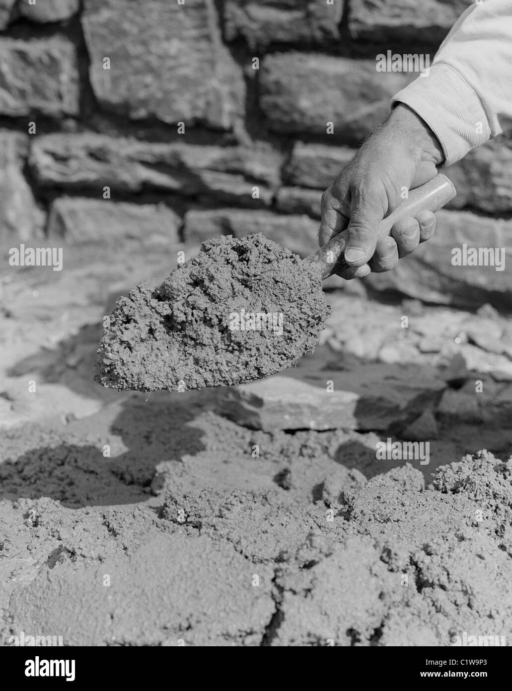 Hand with trowel of cement Stock Photo - Alamy