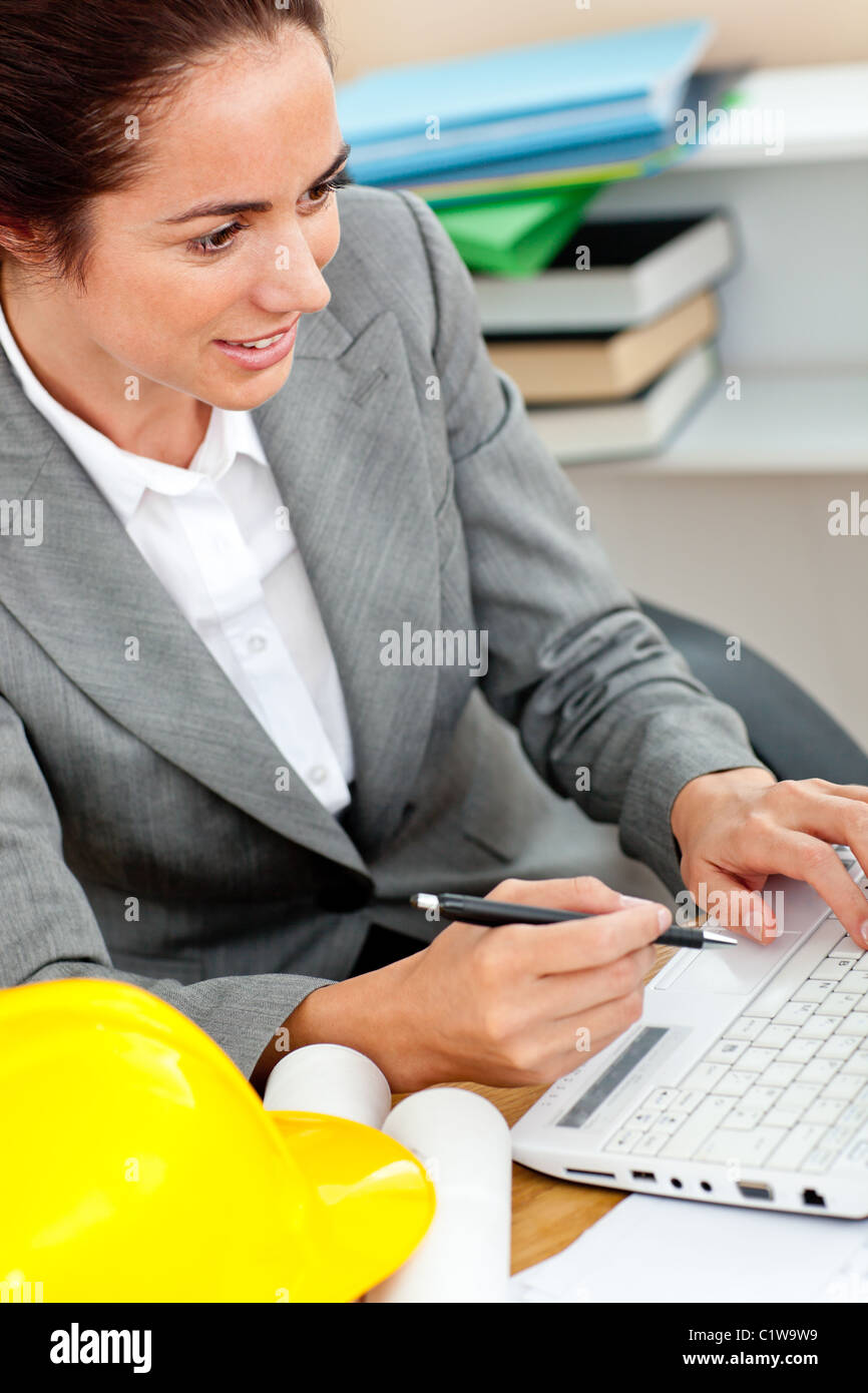 Concentrated female architect studying a project at work in her office ...