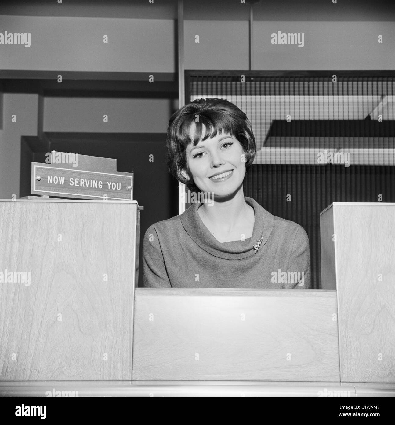 Young woman behind reception desk Black and White Stock Photos & Images ...