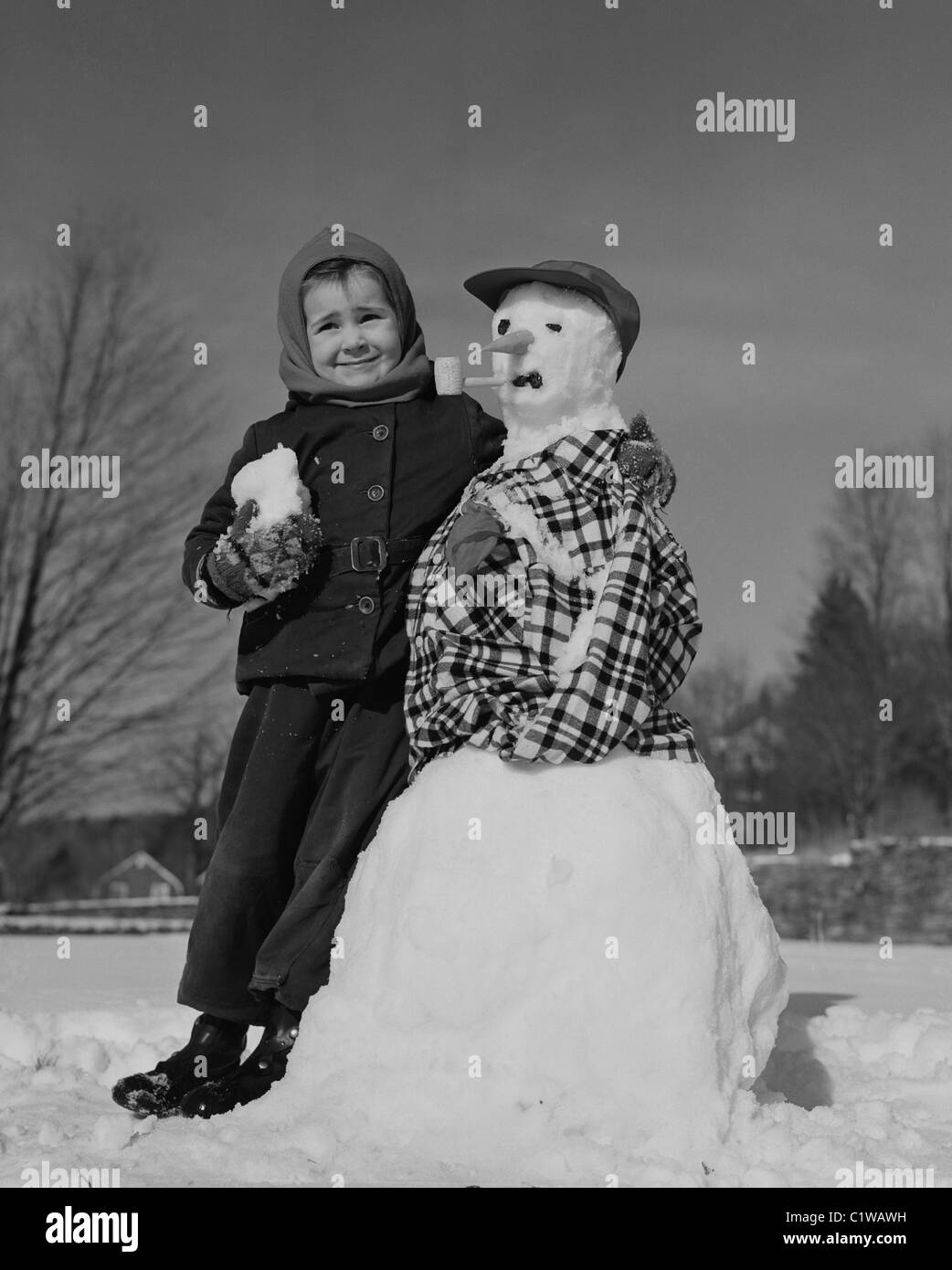 Boy making snowman Stock Photo - Alamy