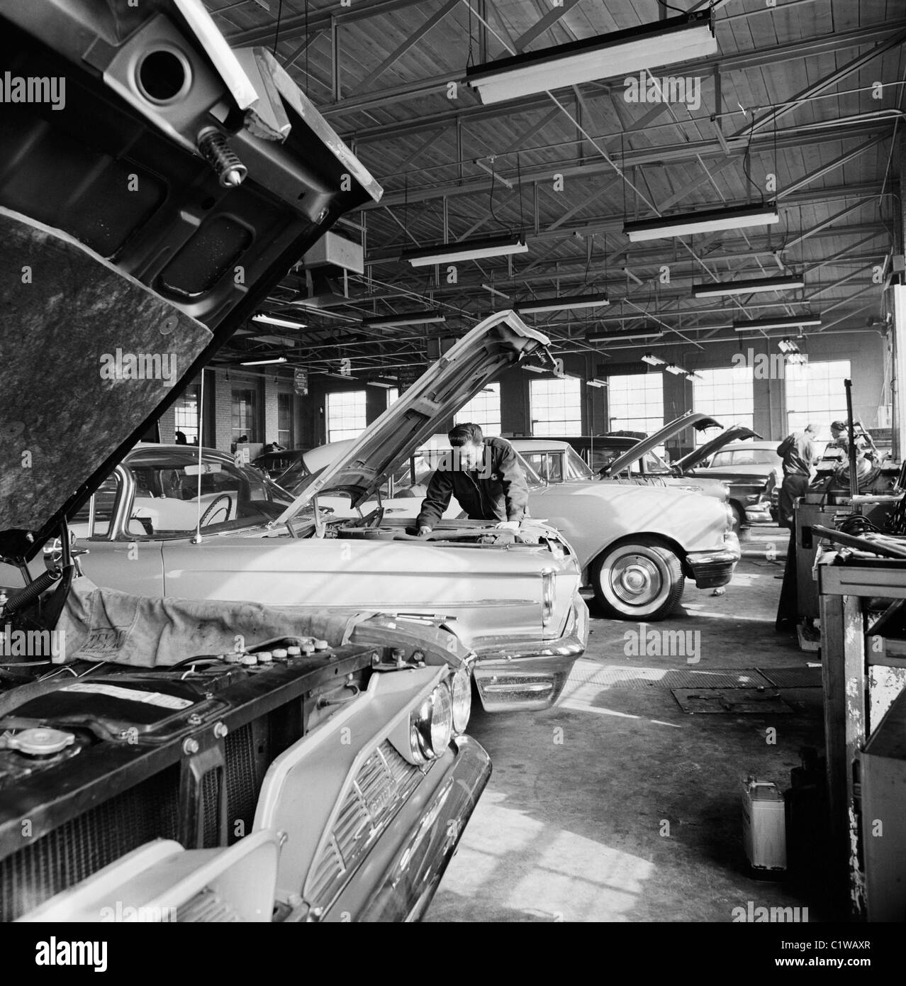 Mechanics working on cars in garage Stock Photo - Alamy