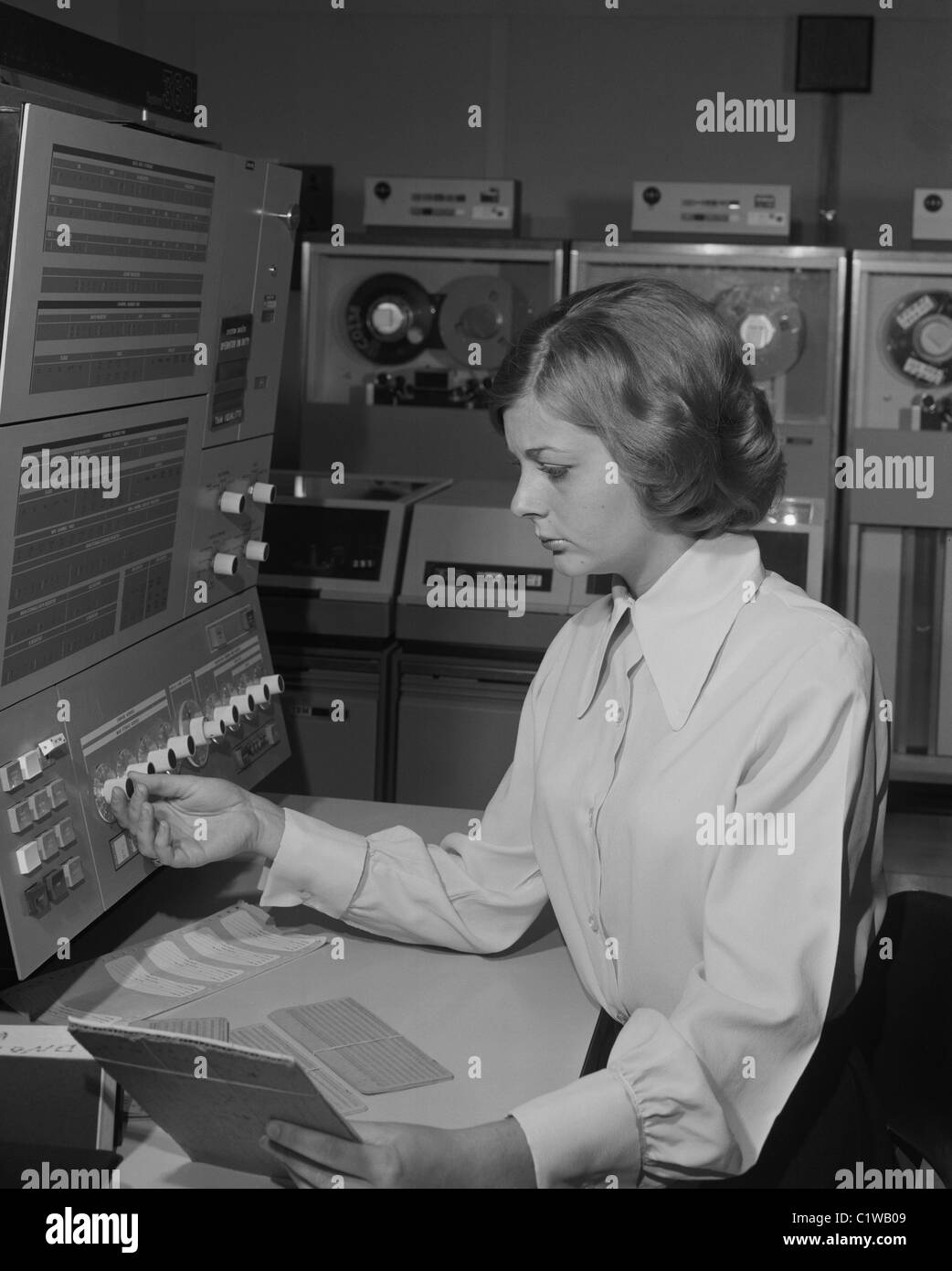 Woman working in studio, adjusting knobs Stock Photo - Alamy