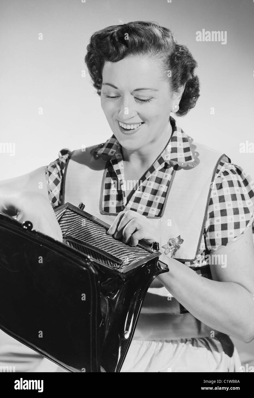 Studio portrait of mid adult woman opening purse Stock Photo - Alamy