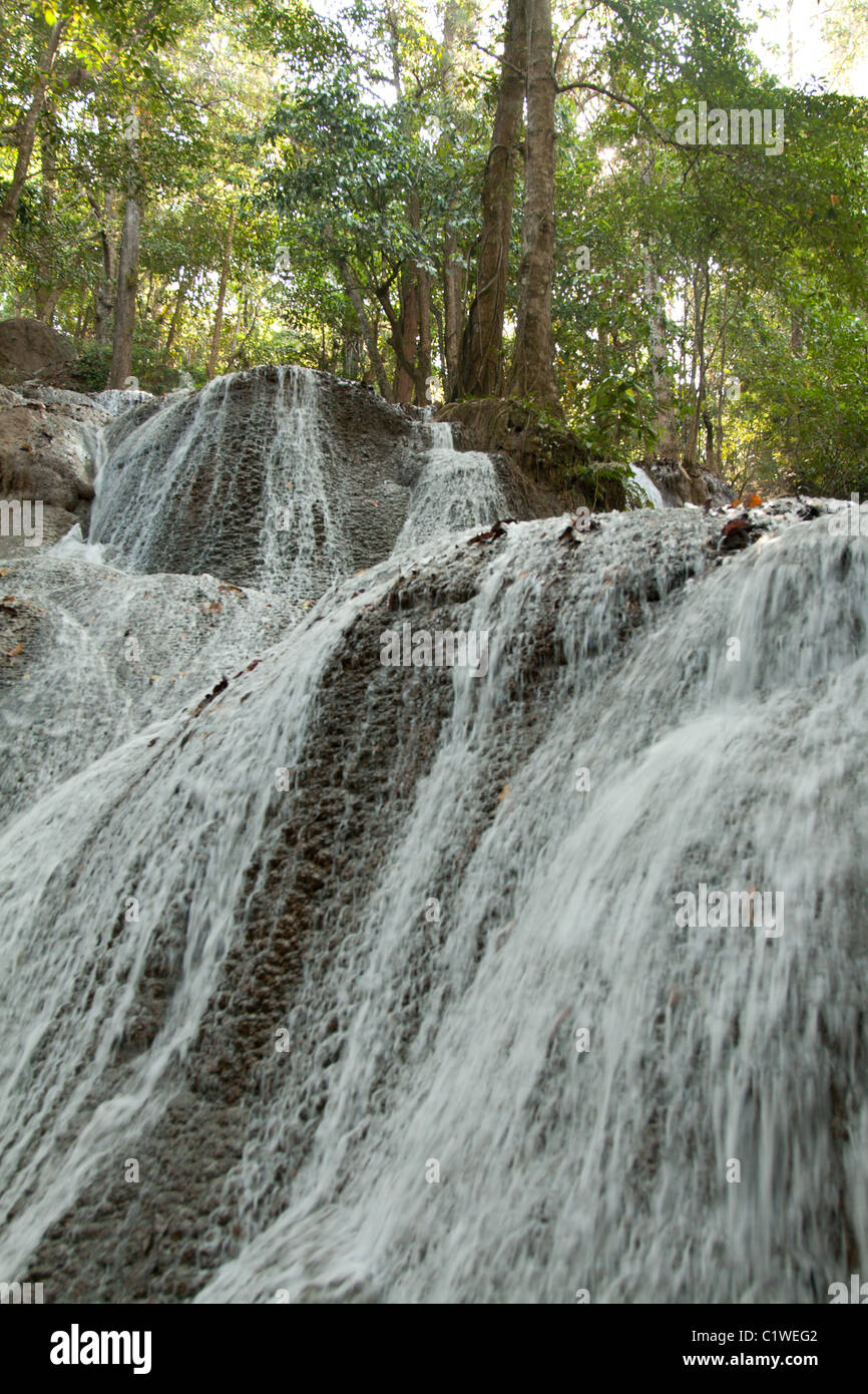 Waterfall in jungle in Thailand, sunshine entrenches through foliage ...