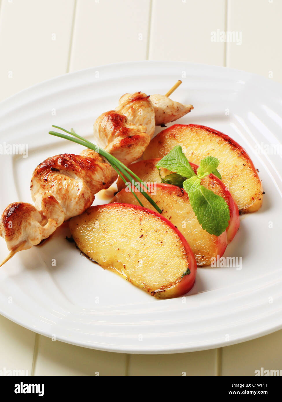Chicken skewer and slices of baked apple Stock Photo - Alamy